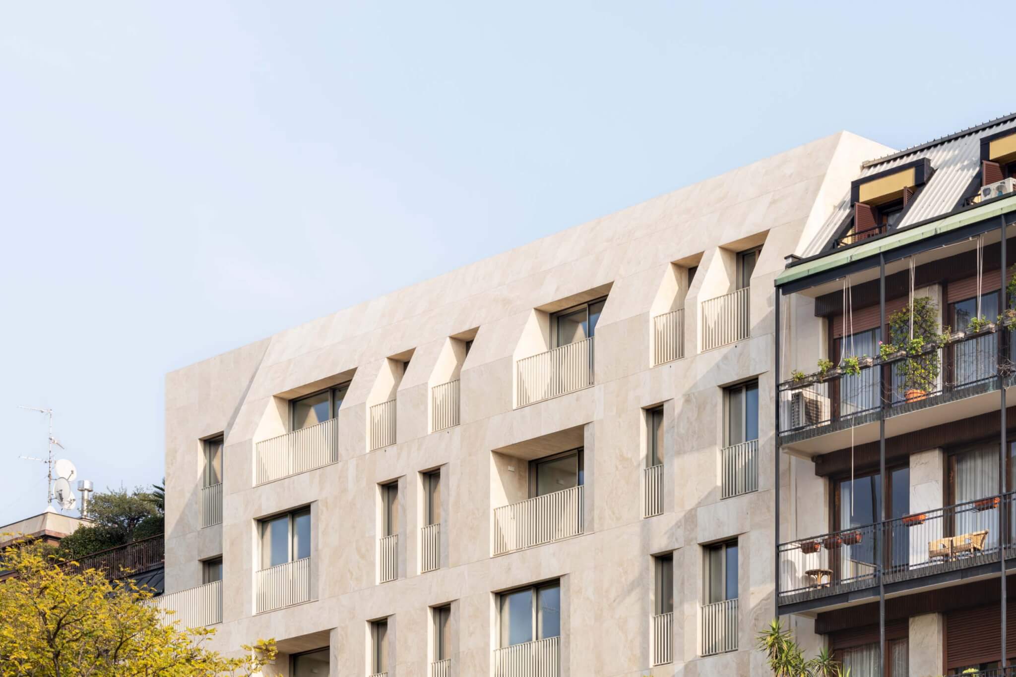 Ebpc delivers a monolithic apartment building clad in travertine with ...